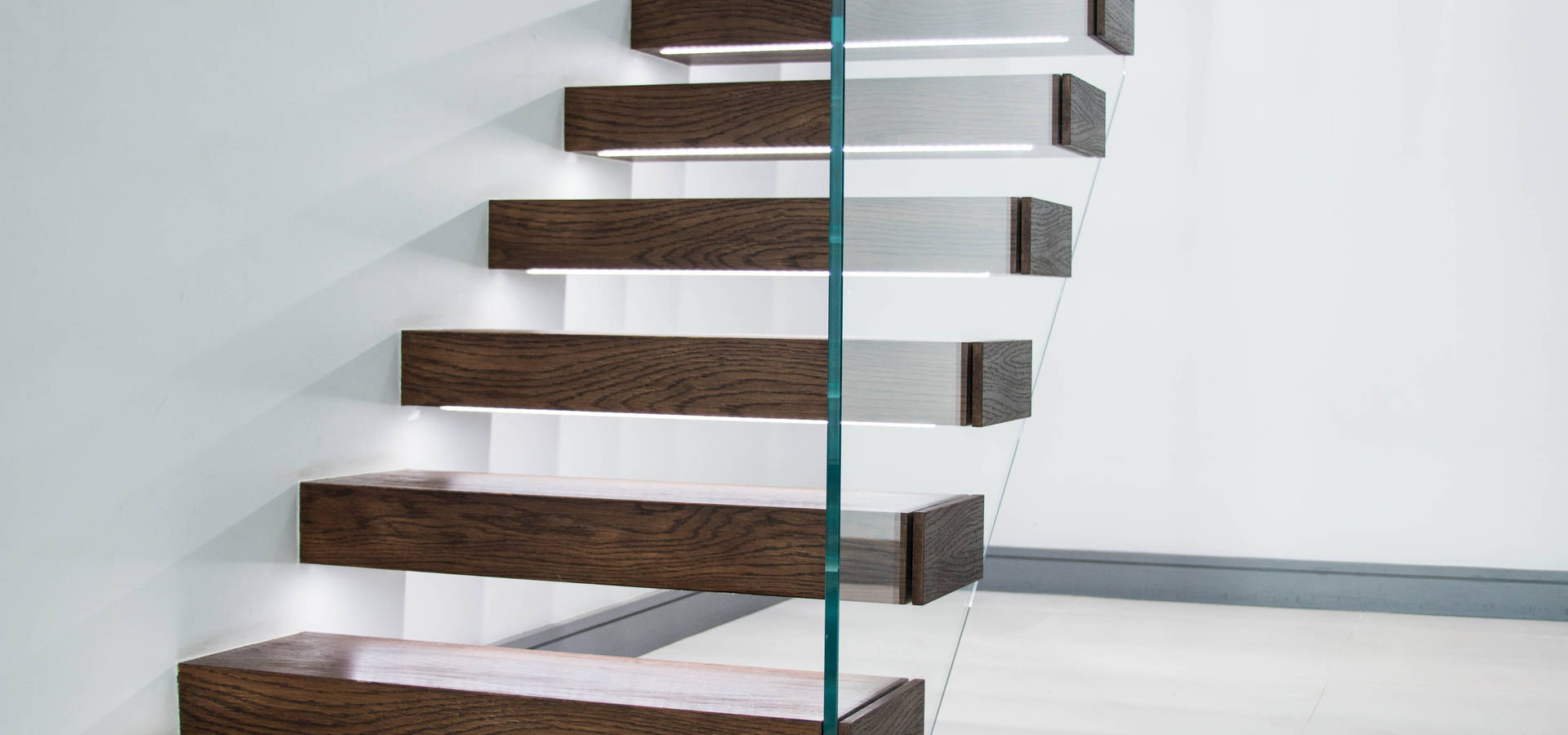A custom-made floating staircase with oak-clad treads, a clear-glass ...