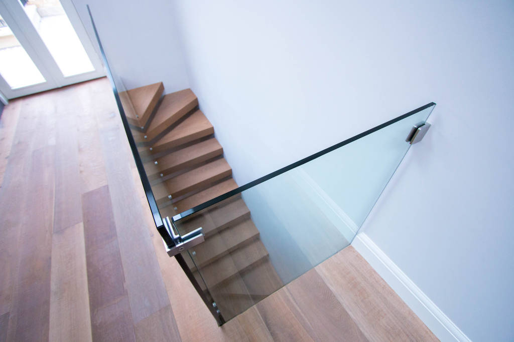 Custom-built cantilever staircase with oak-clad treads and frameless ...