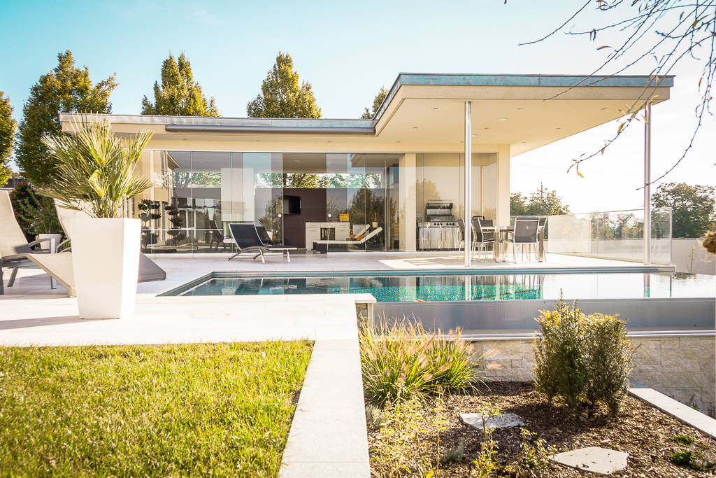Poolhaus mit outdoorküche – geschützt und verglast mit schiebetüren aus ...